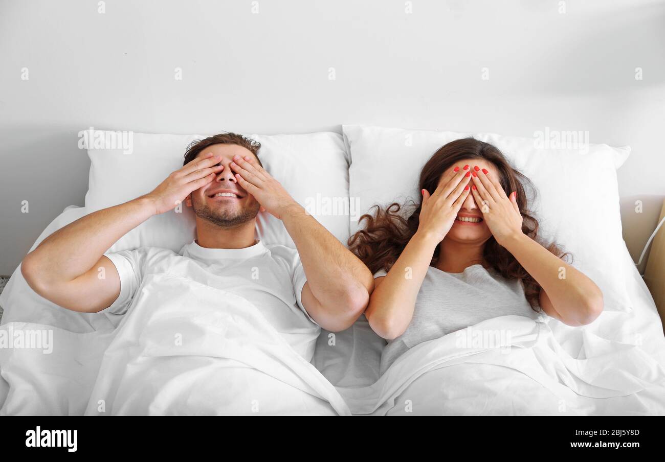 Happy couple snoozing on bed Stock Photo - Alamy