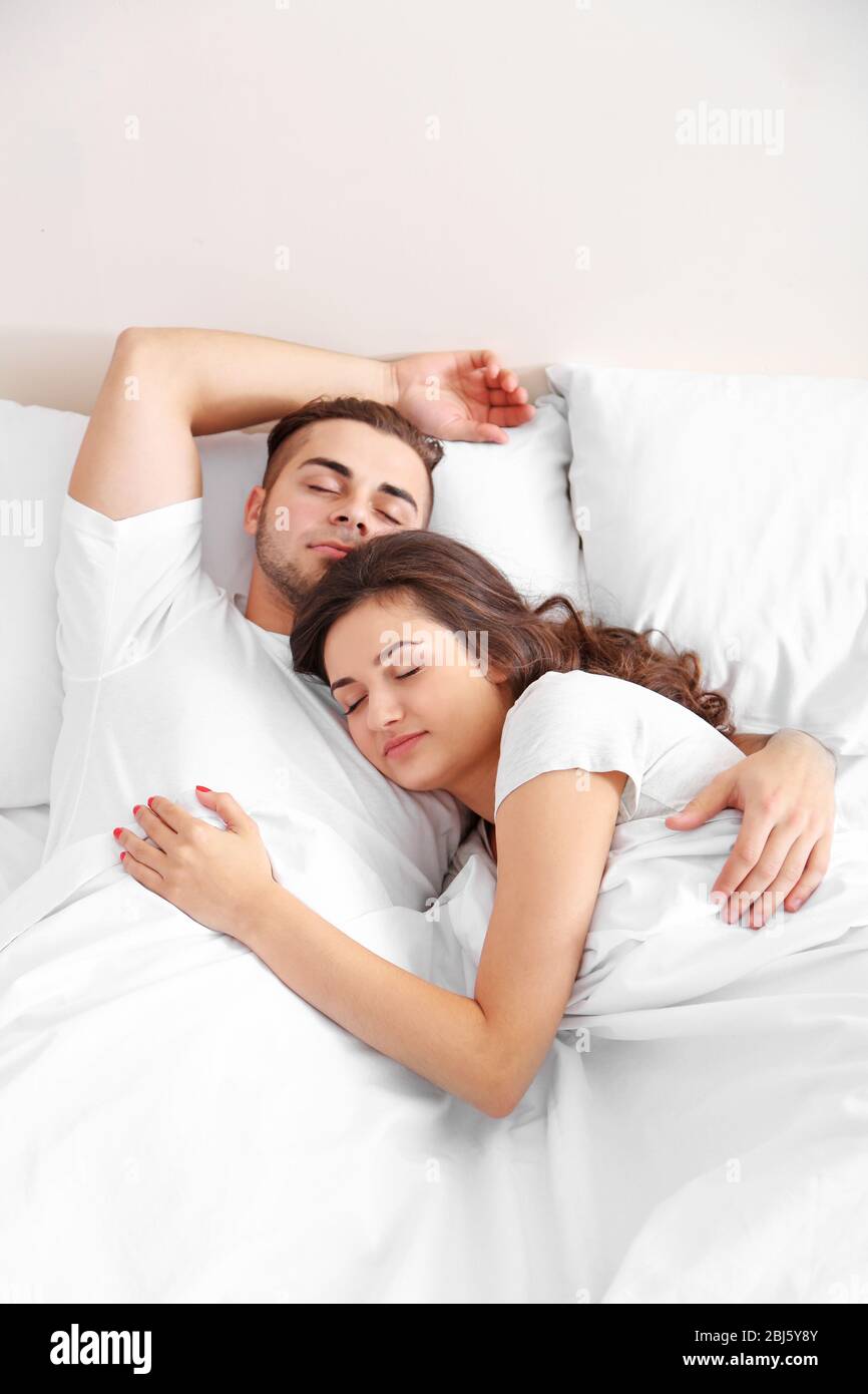Happy couple snoozing on bed Stock Photo - Alamy