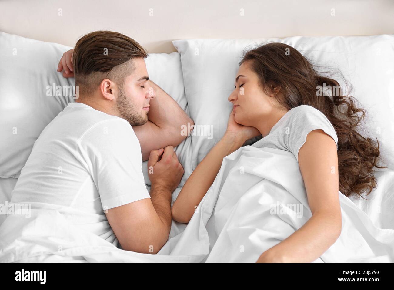 Happy couple snoozing on bed Stock Photo - Alamy