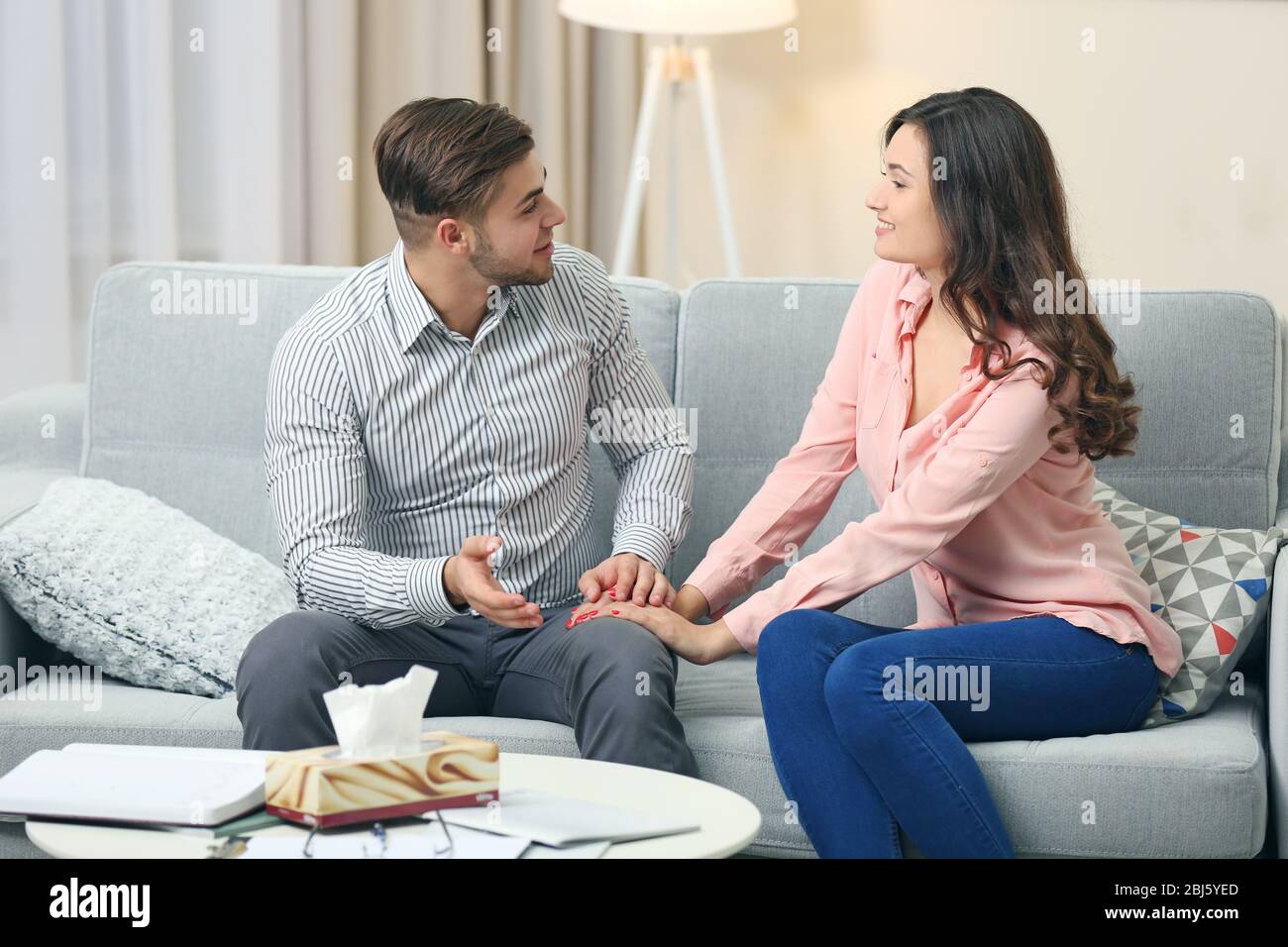 Happy couple on sofa, on home interior background Stock Photo - Alamy