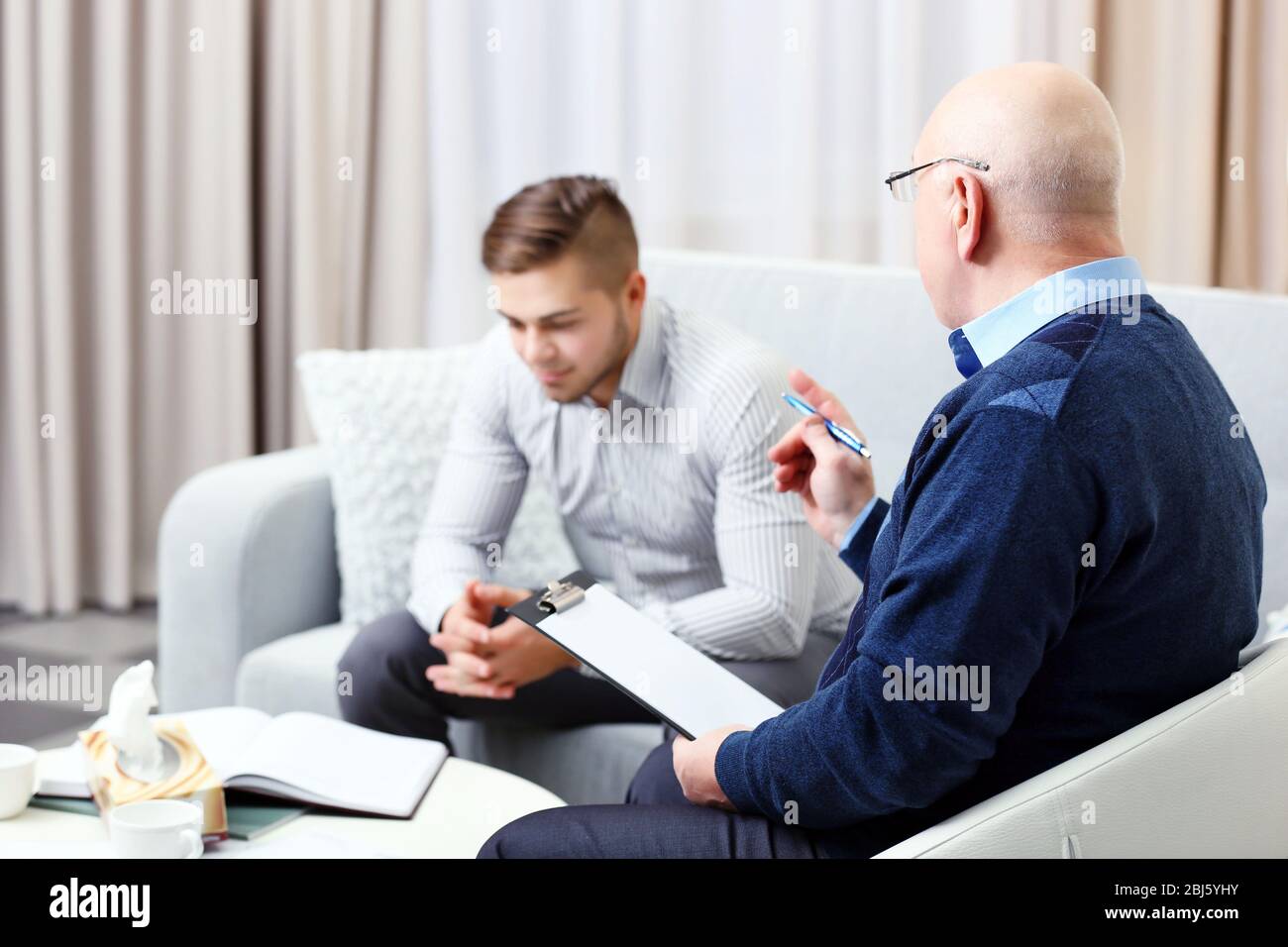 Young man on reception at psychologist Stock Photo - Alamy