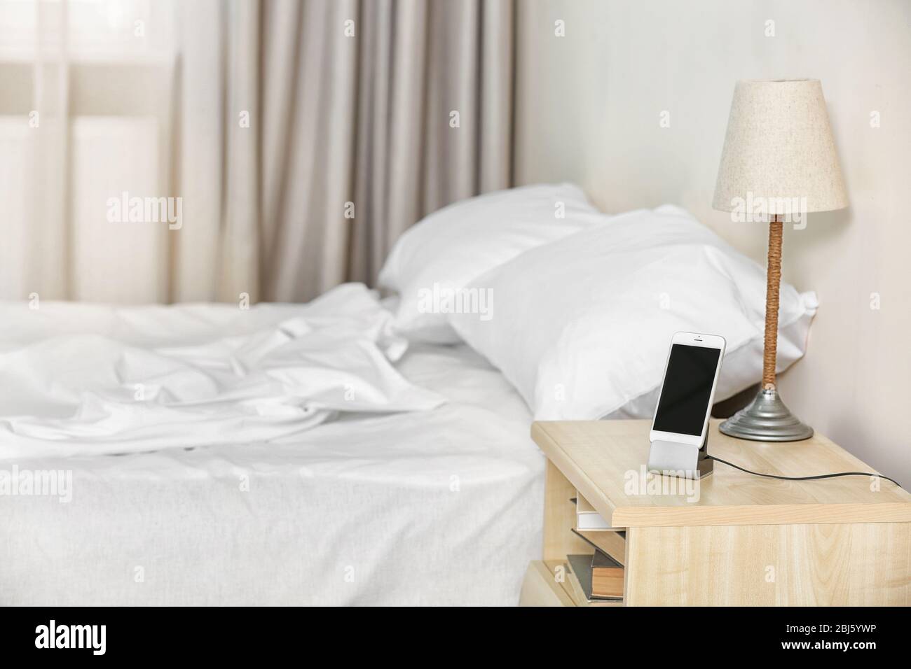 Smart phone on nightstand in bedroom Stock Photo - Alamy