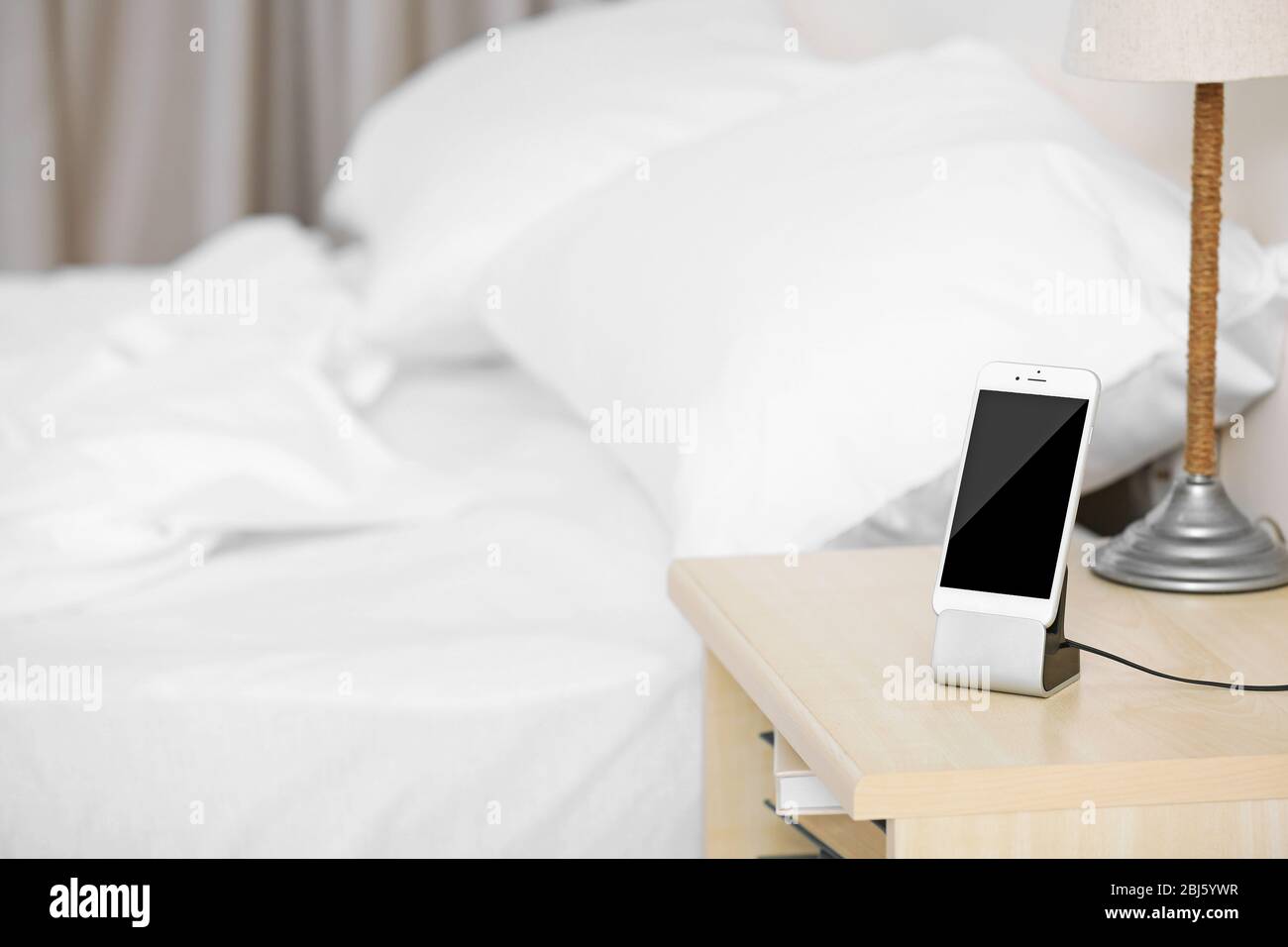 Smart phone on nightstand in bedroom Stock Photo - Alamy