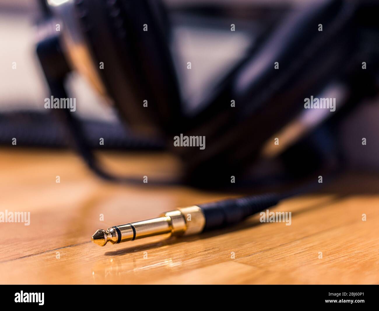 Black Hi-Fi headphones with a gold input jack on a wooden floor Stock ...
