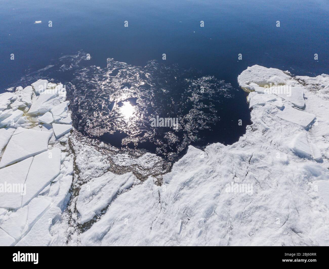 Aerial view of the border of ice broken into pieces of various shapes ...