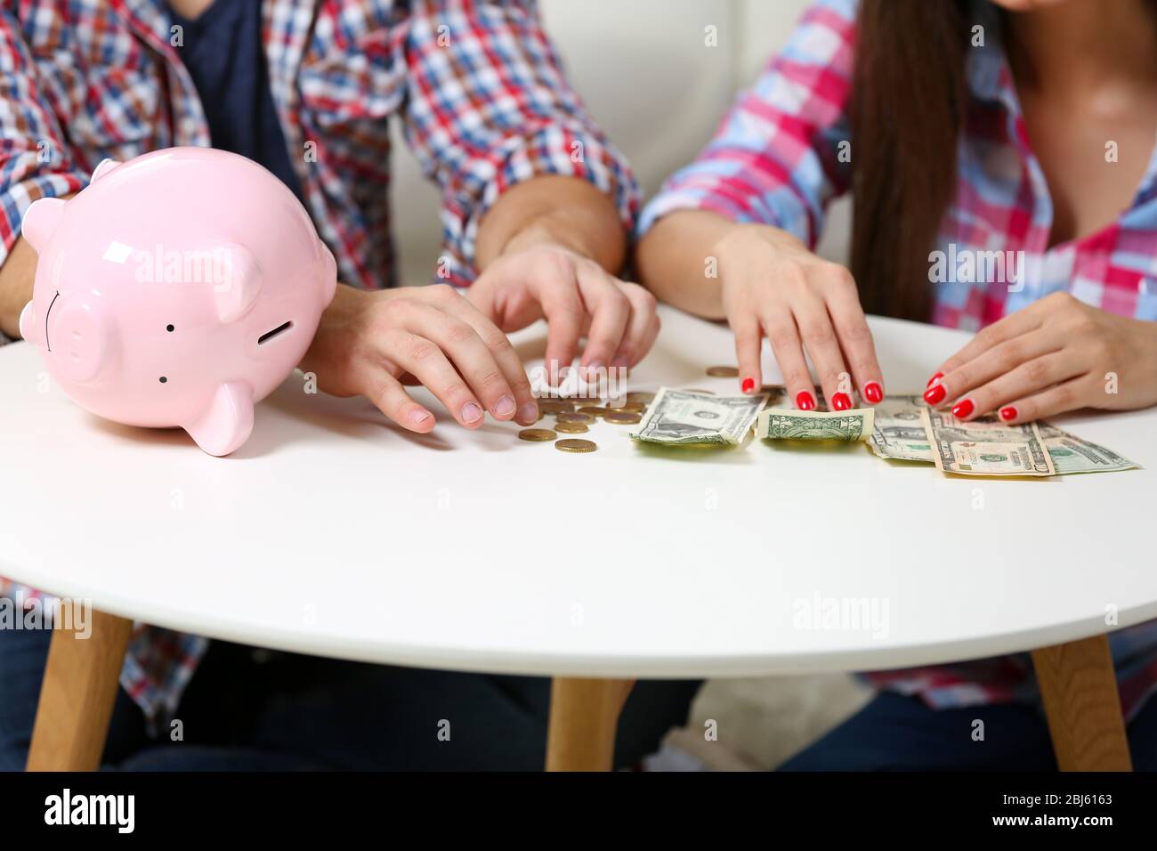 Happy couple counting money from the moneybox Stock Photo - Alamy