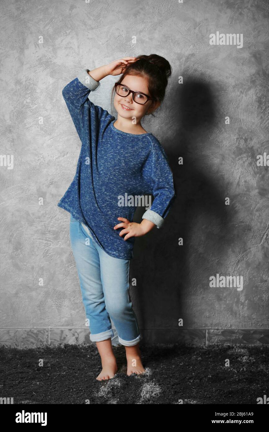 Portrait of little fashion kid girl on gray wall background Stock Photo ...