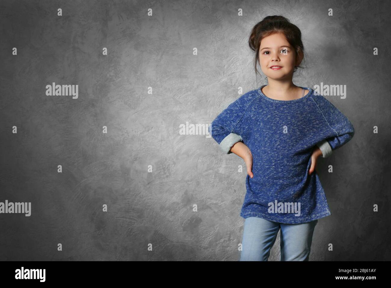 Portrait of little fashion kid girl on gray wall background Stock Photo ...
