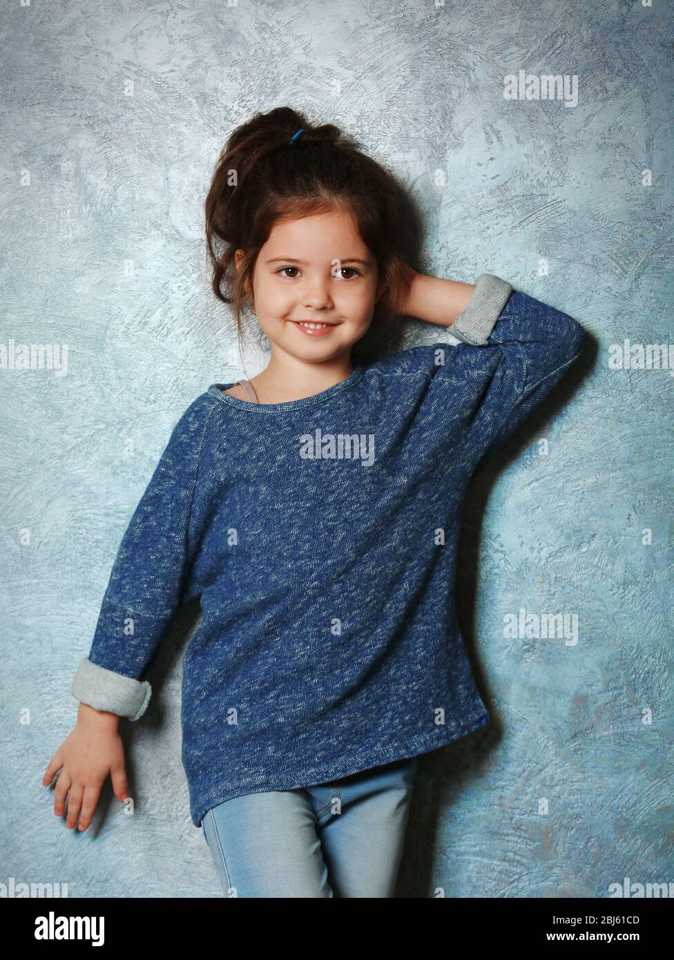 Portrait of little fashion kid girl on gray wall background Stock Photo ...