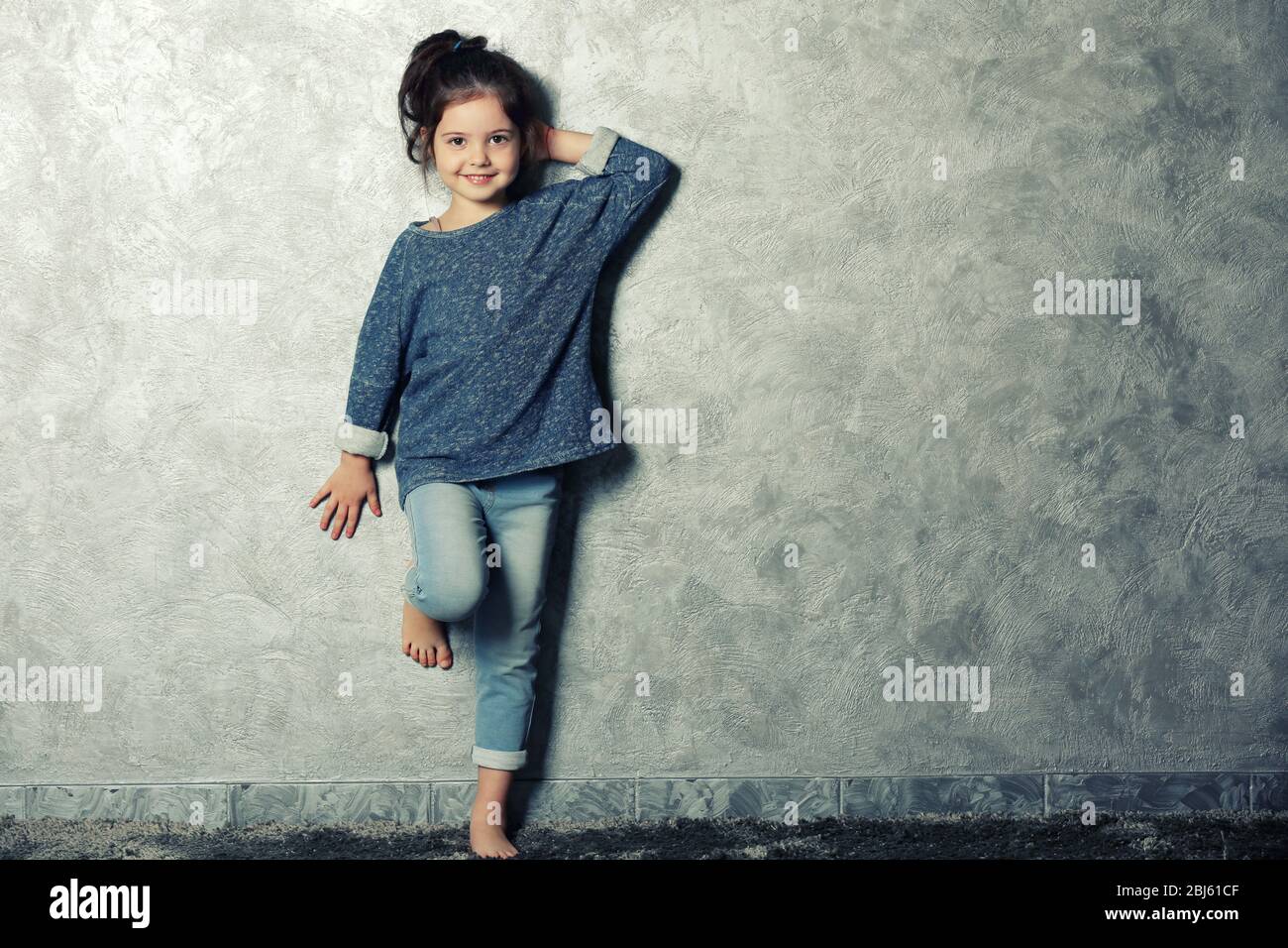 Portrait of little fashion kid girl on gray wall background Stock Photo ...