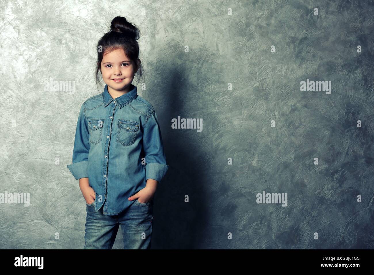 Portrait of little fashion kid girl on gray wall background Stock Photo ...