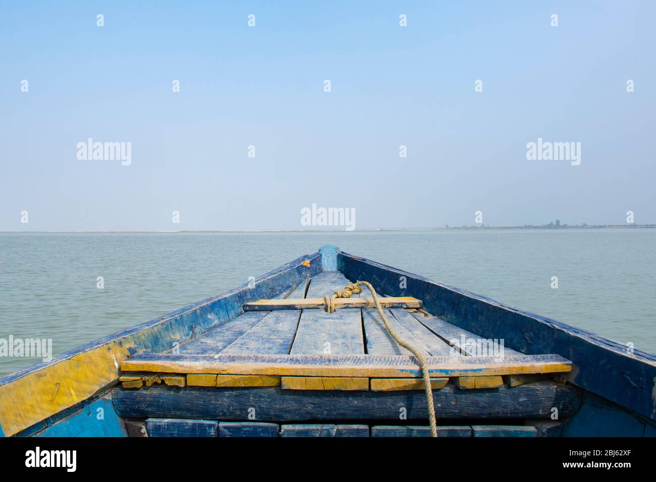 Wooden boat and a island in distance Stock Photo - Alamy
