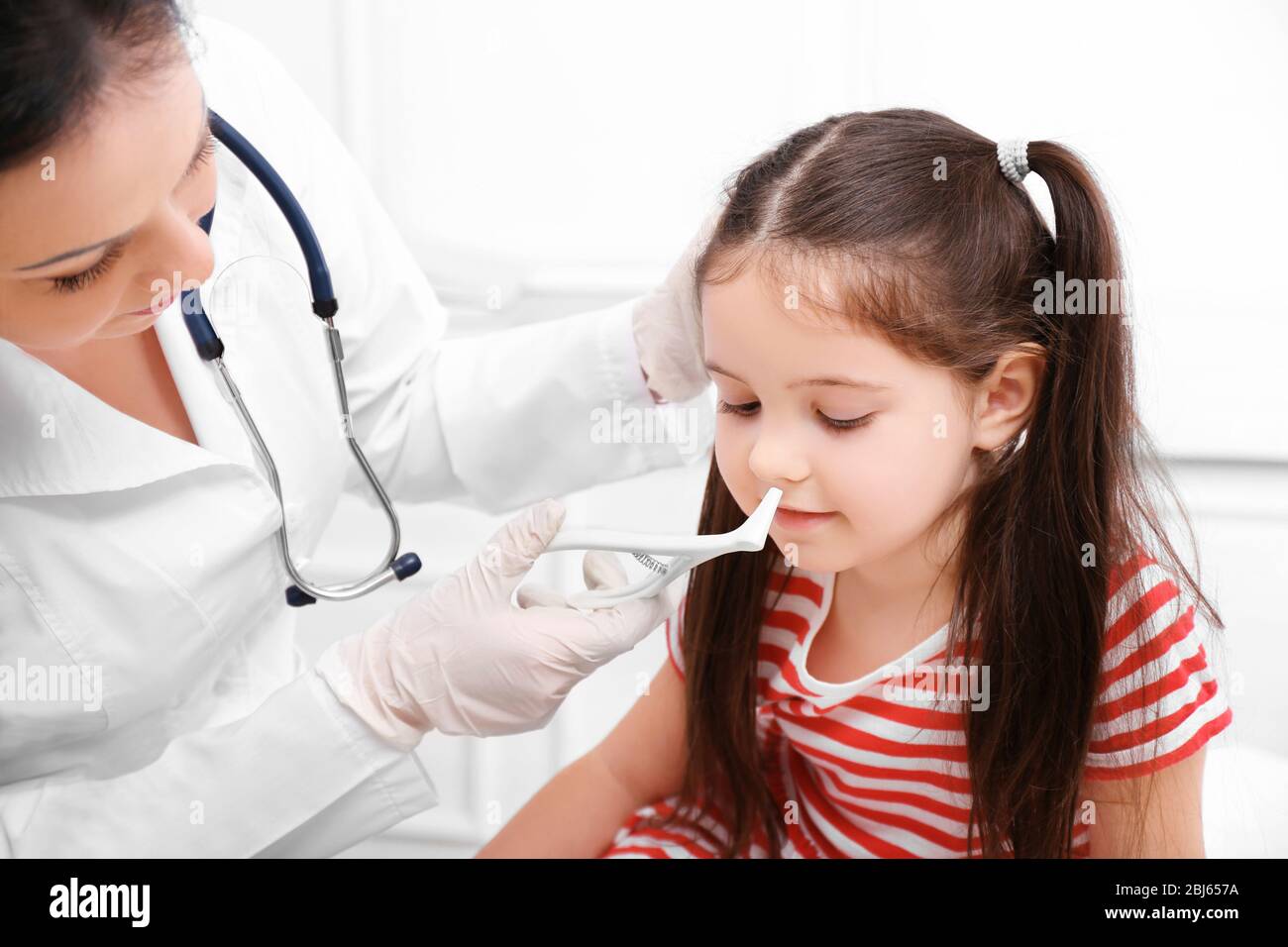 Doctor examining child's nose Stock Photo - Alamy