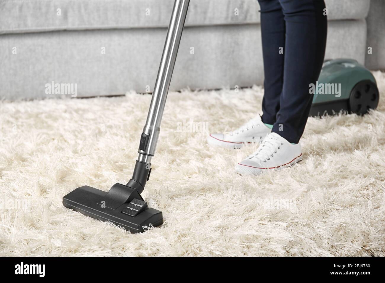 Cleaning concept - woman cleaning the room with carpet sweeper, close ...