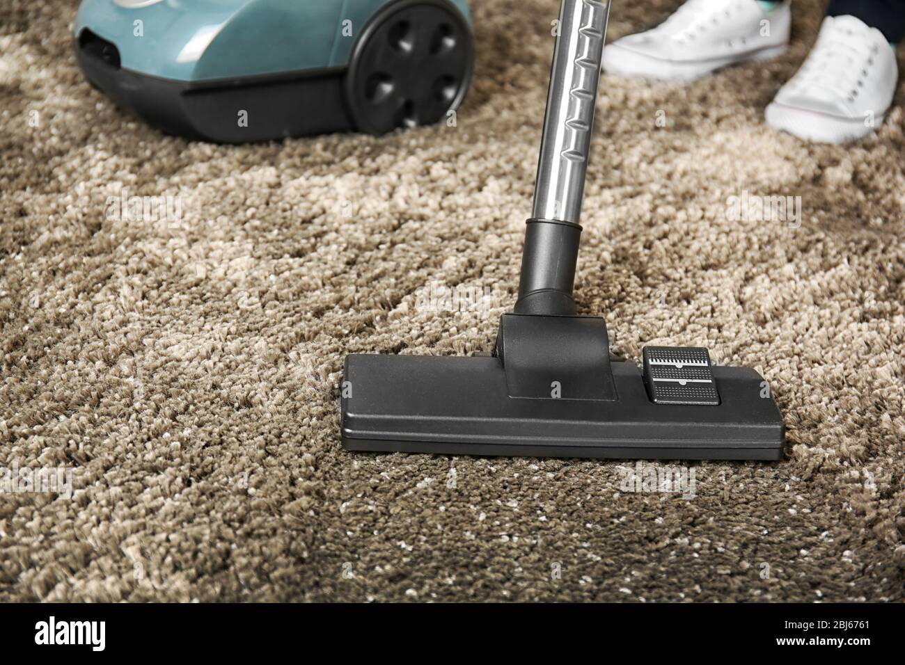 Cleaning concept - woman cleaning the room with carpet sweeper, close ...