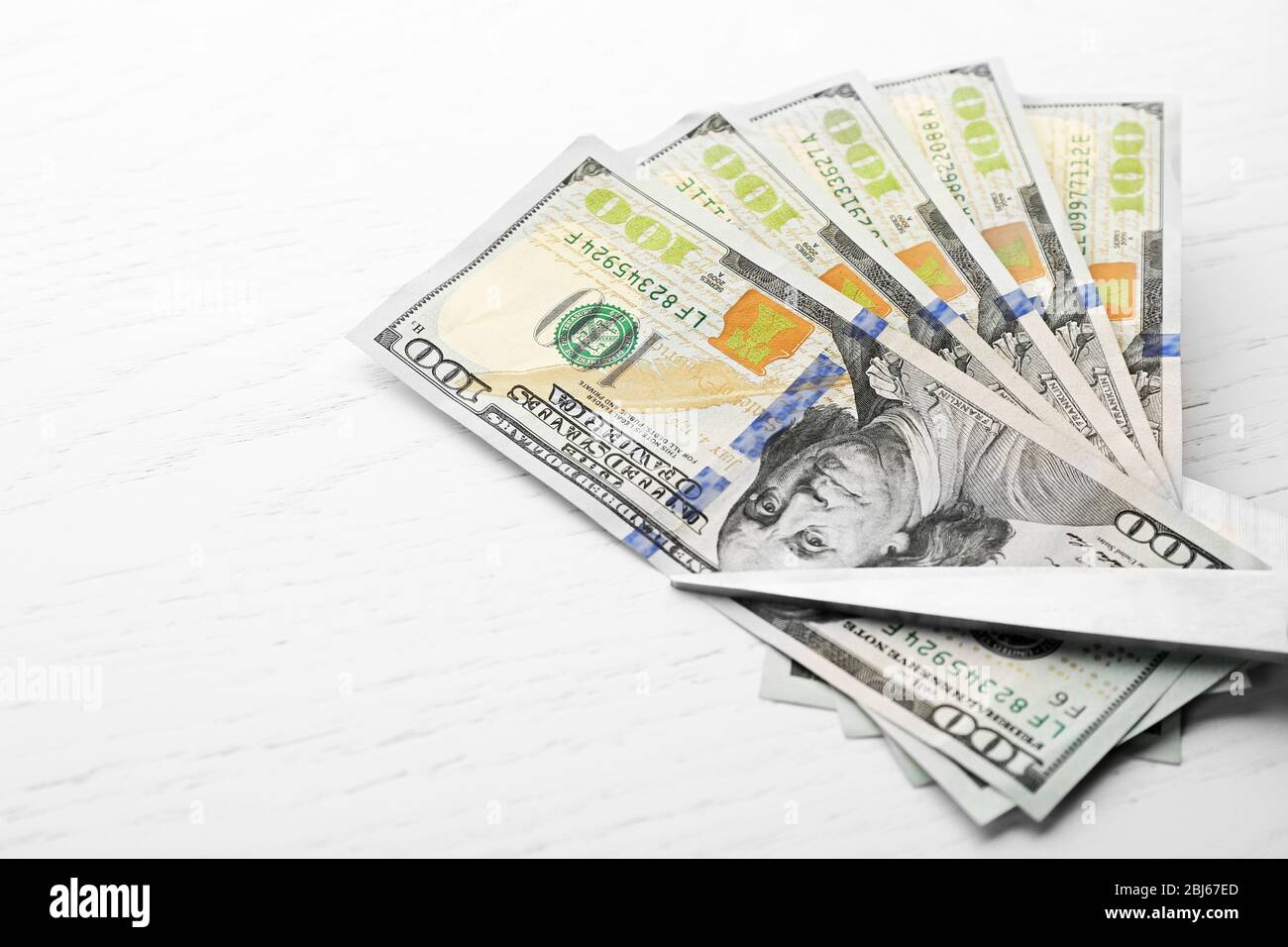 Scissors cuts dollar banknote on table Stock Photo - Alamy