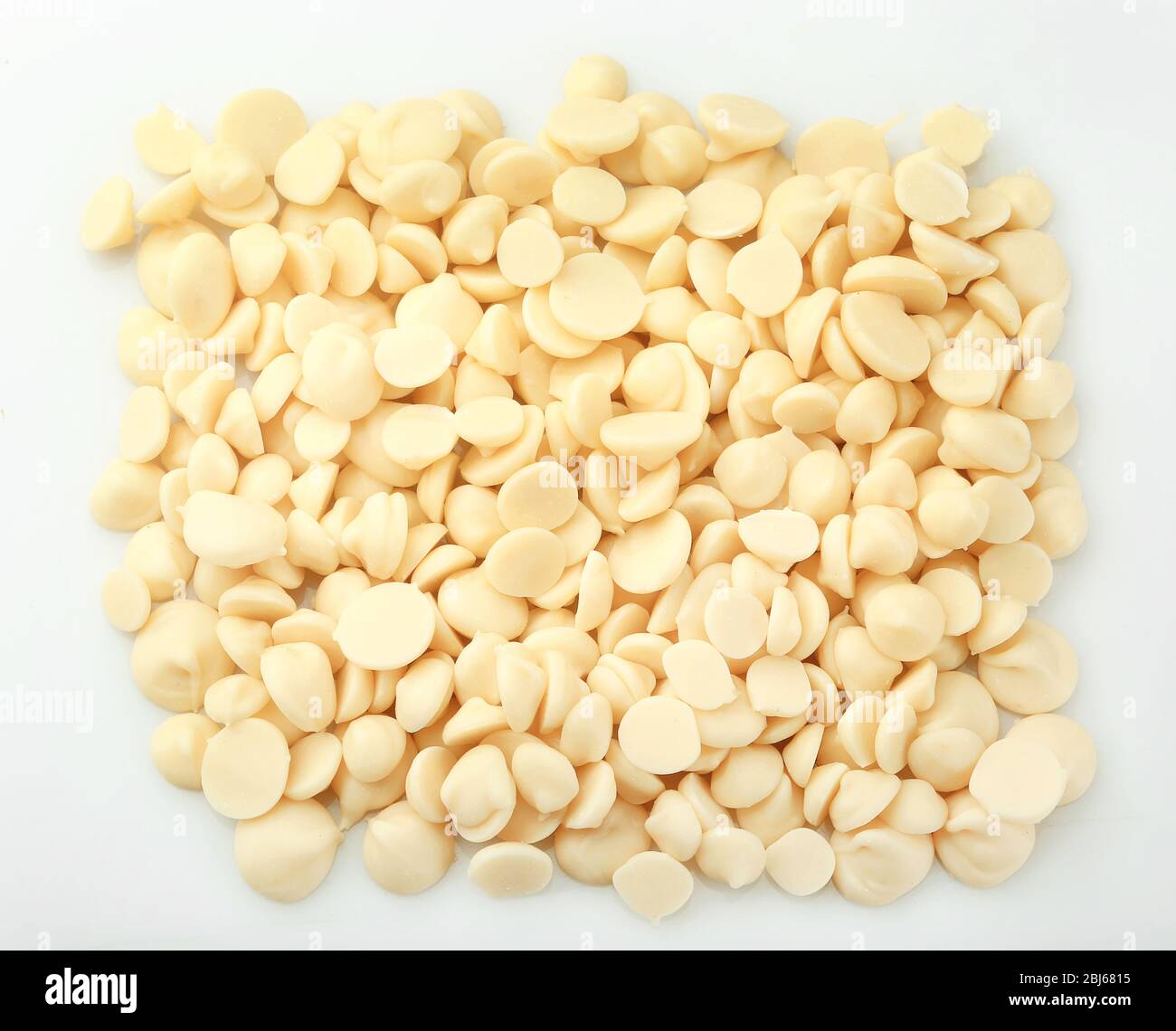 White chocolate morsels isolated on white Stock Photo - Alamy