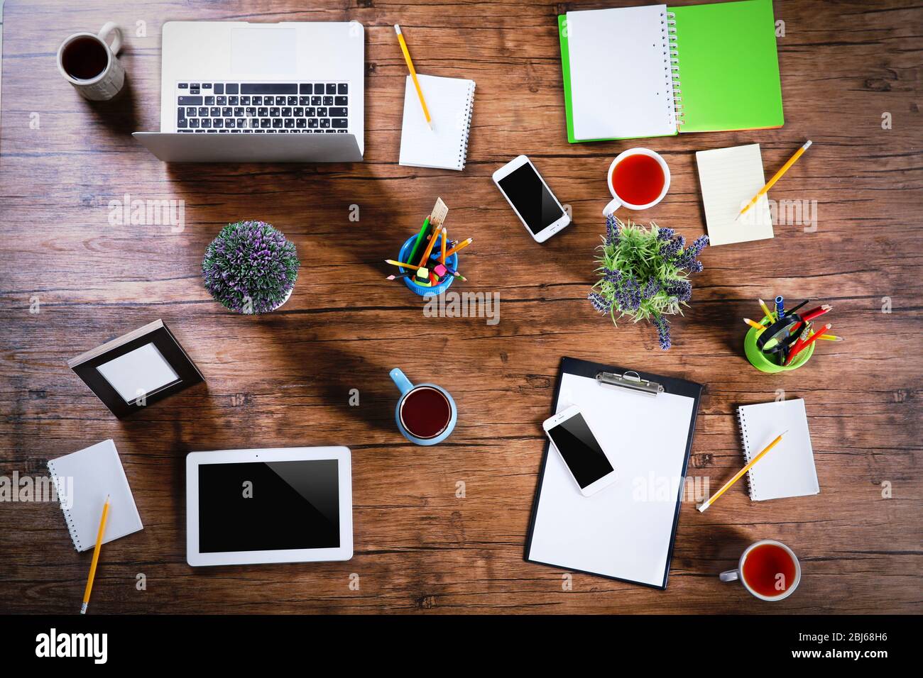 Session concept. Tablet, laptop, papers and cups of tea on wooden ...