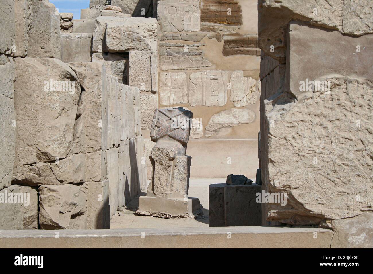 ruined headless statue in the guise of god Osiris in Karnak Temple ...