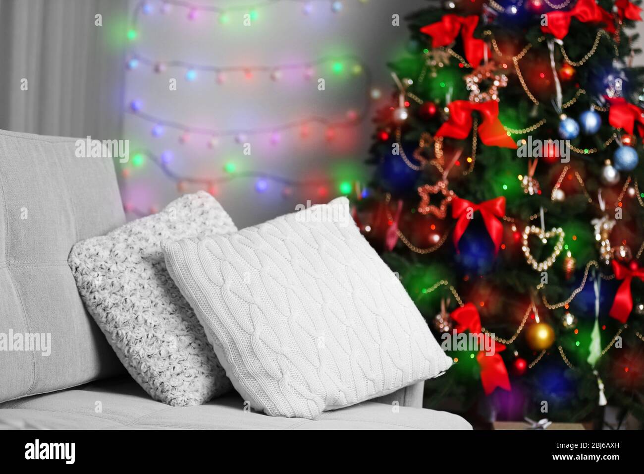 Decorated Christmas tree beside sofa Stock Photo - Alamy