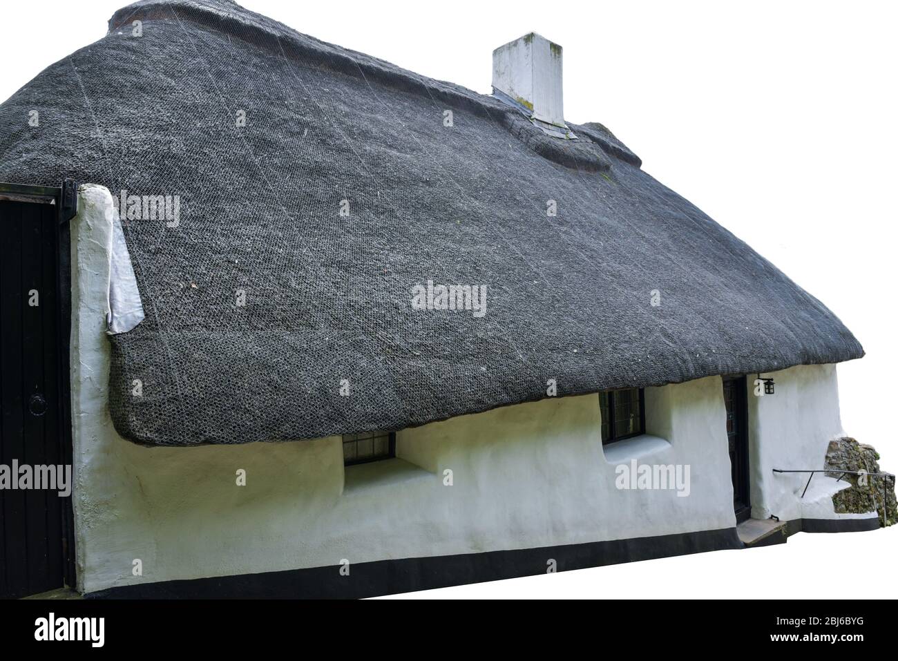 Traditional reed thatched roof of a stone built cottage isolated from ...