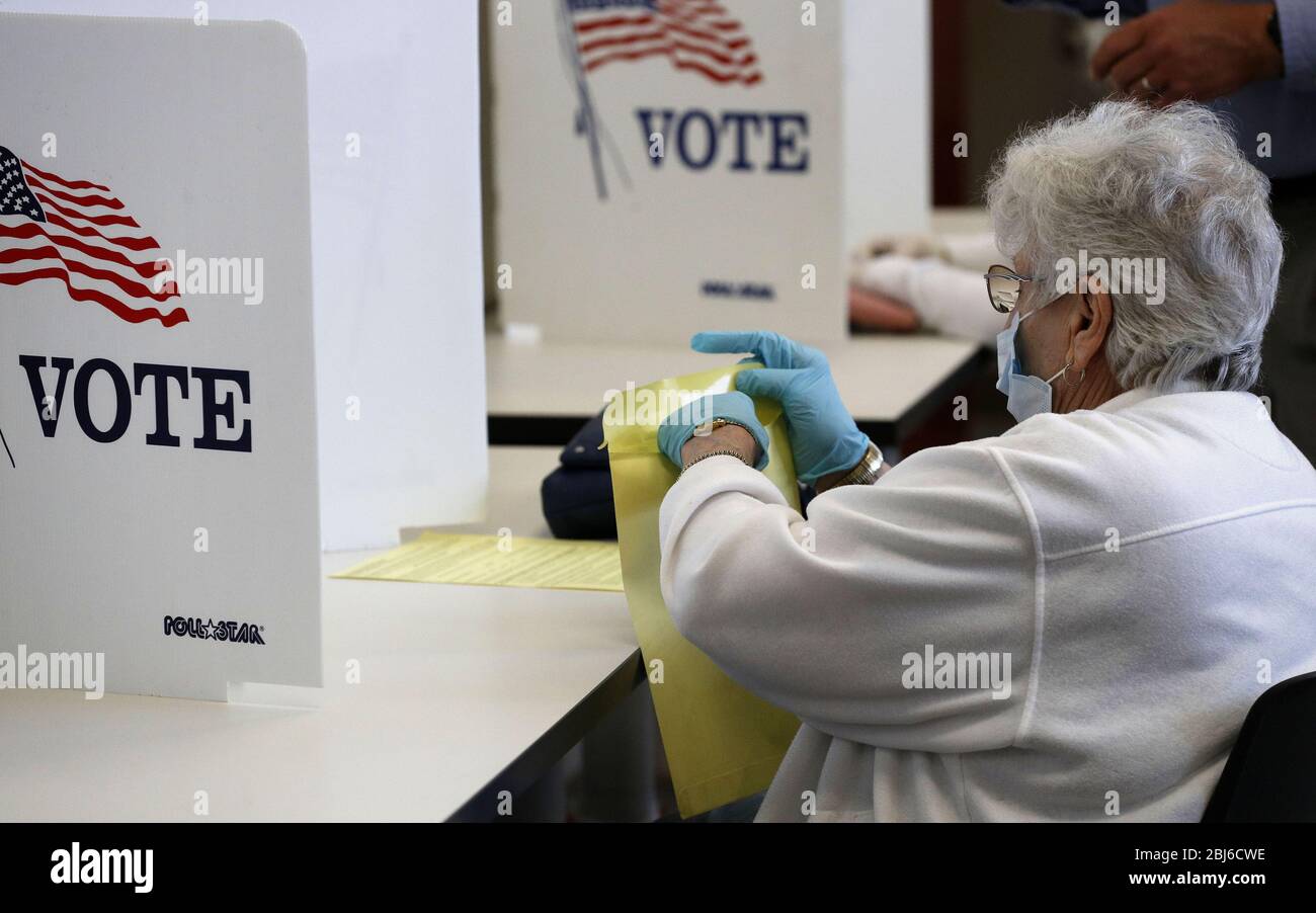 Medina, United States. 28th Apr, 2020. A voter places her ballot in the ...