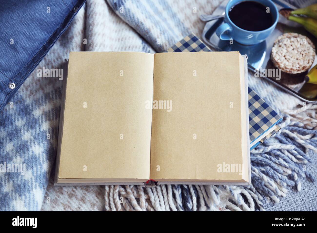 Open book, plaid and coffee on sofa. Top view Stock Photo - Alamy