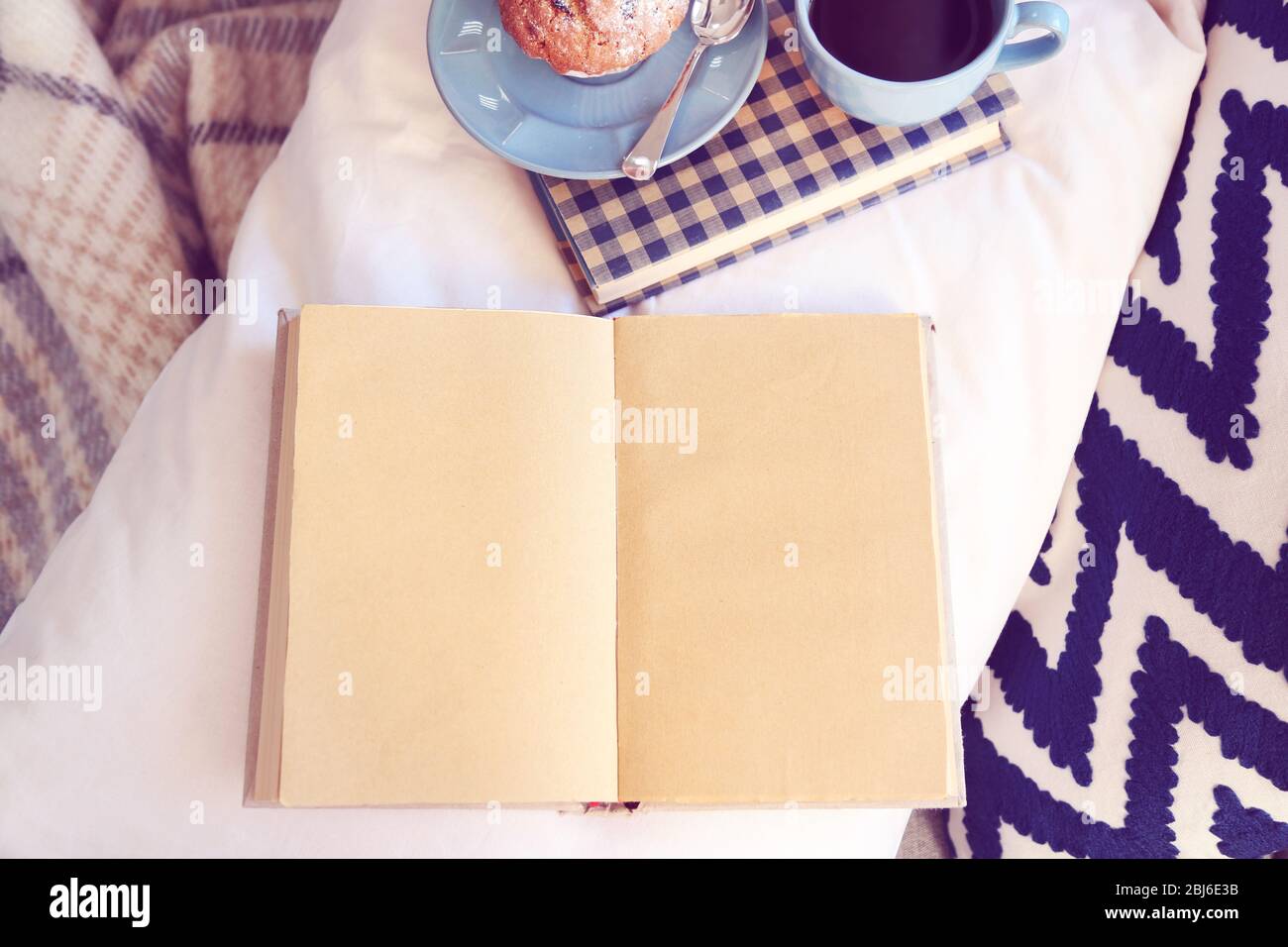 Open book, plaid and coffee on sofa. Top view Stock Photo - Alamy