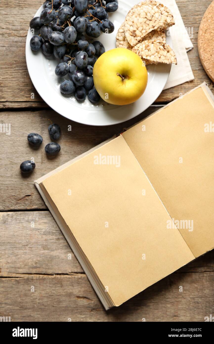 Open book and snack on wooden table background Stock Photo - Alamy