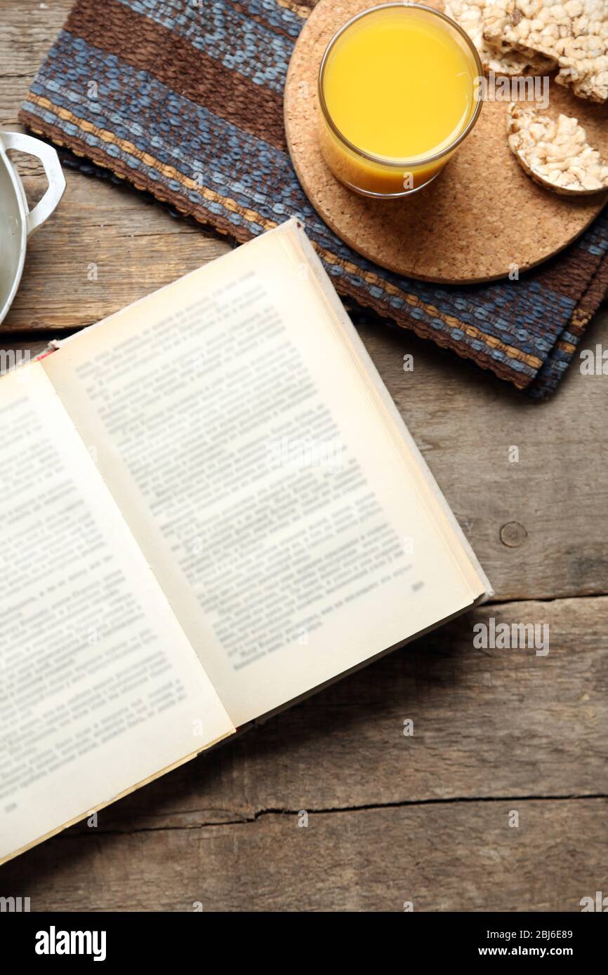 Open book and snack on wooden table background Stock Photo - Alamy