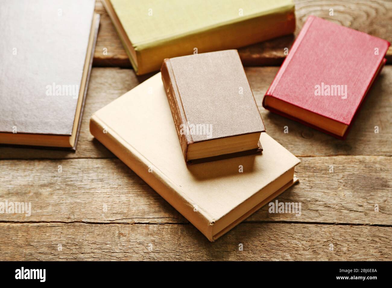 Pile of books on wooden background Stock Photo - Alamy