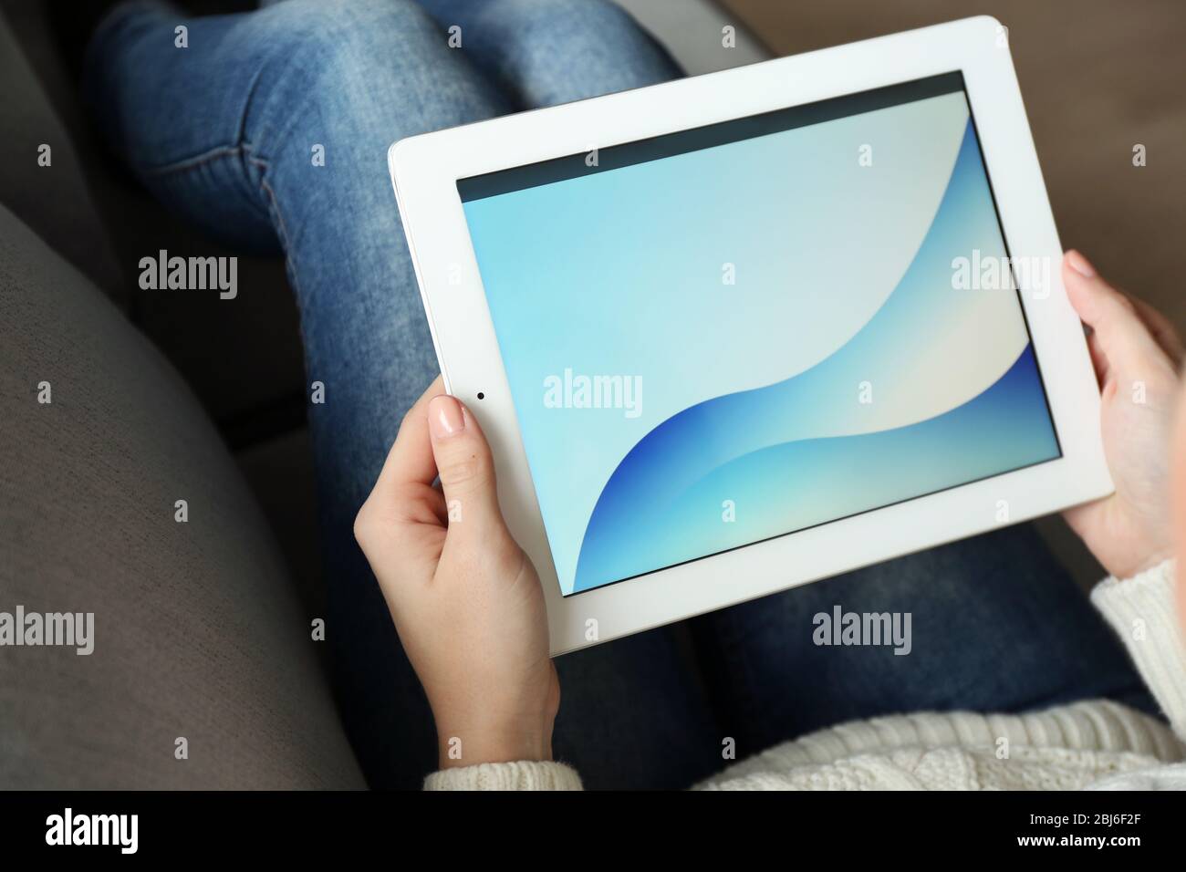 Female hand holding PC tablet on home interior background Stock Photo ...