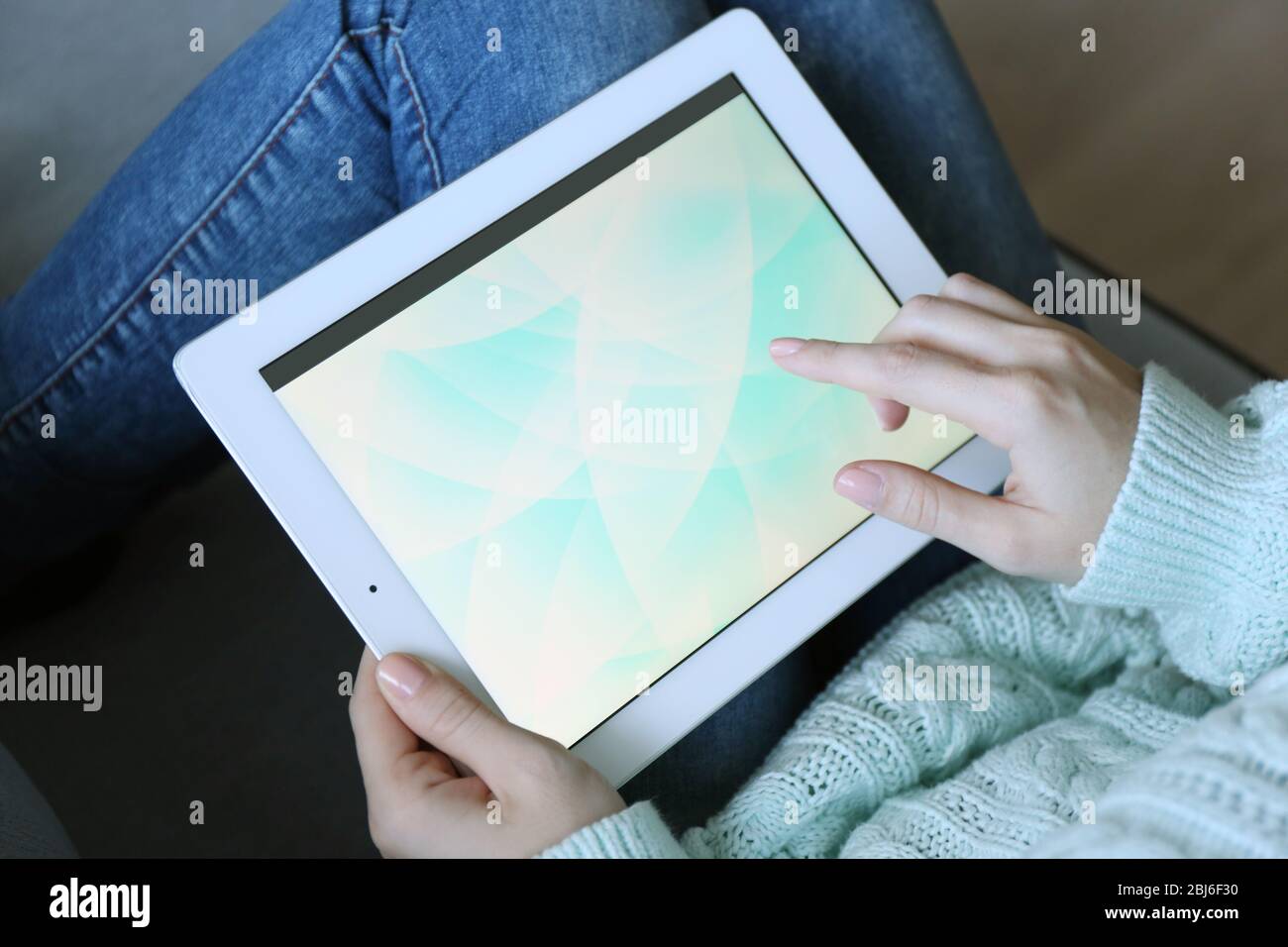 Female hand holding PC tablet on home interior background Stock Photo ...