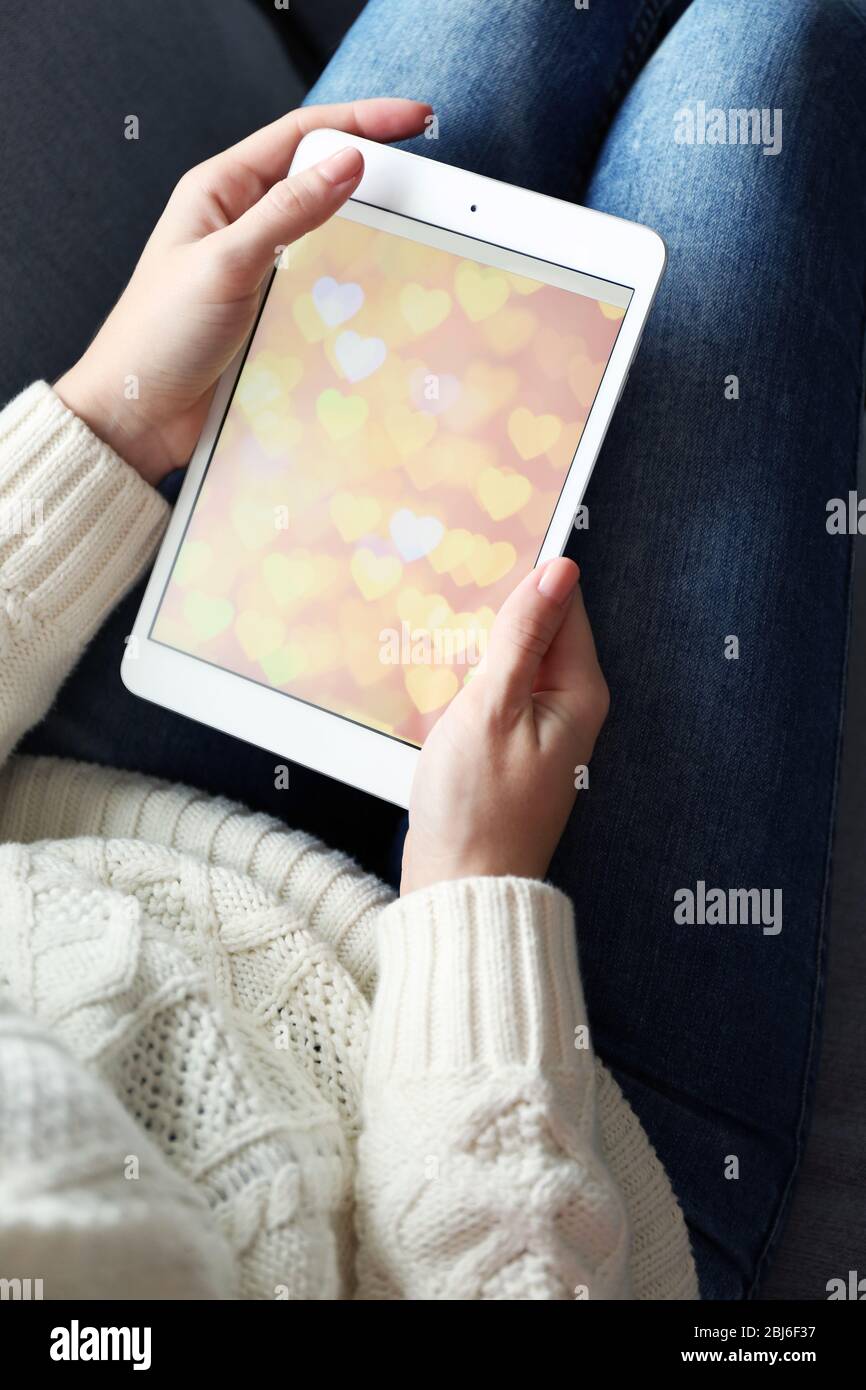 Female hand holding PC tablet on home interior background Stock Photo ...
