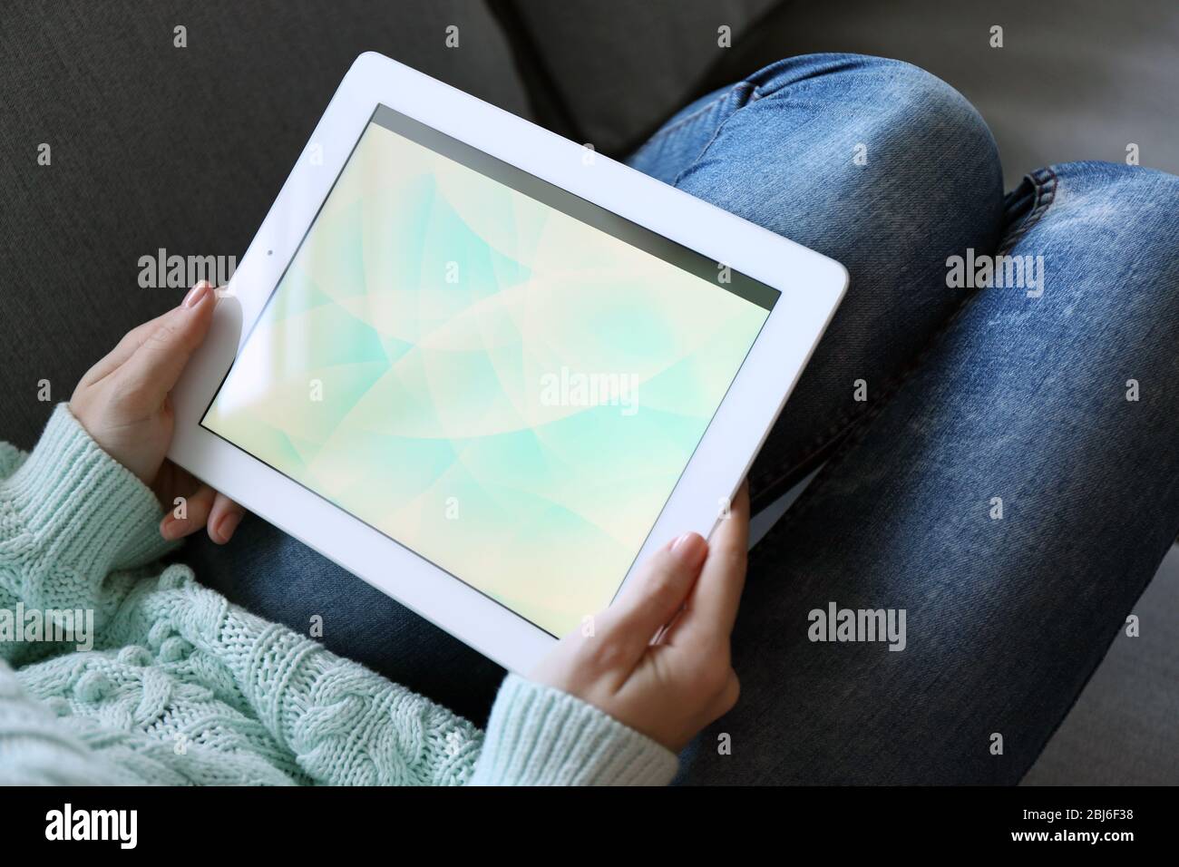 Female hand holding PC tablet on home interior background Stock Photo ...