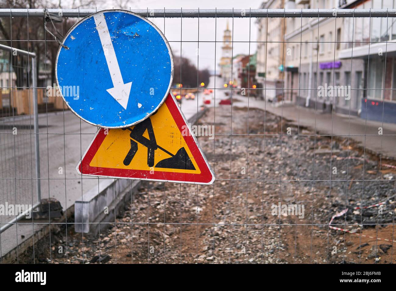 road signs Roadworks ahead and Pass on this side on the fence in front ...