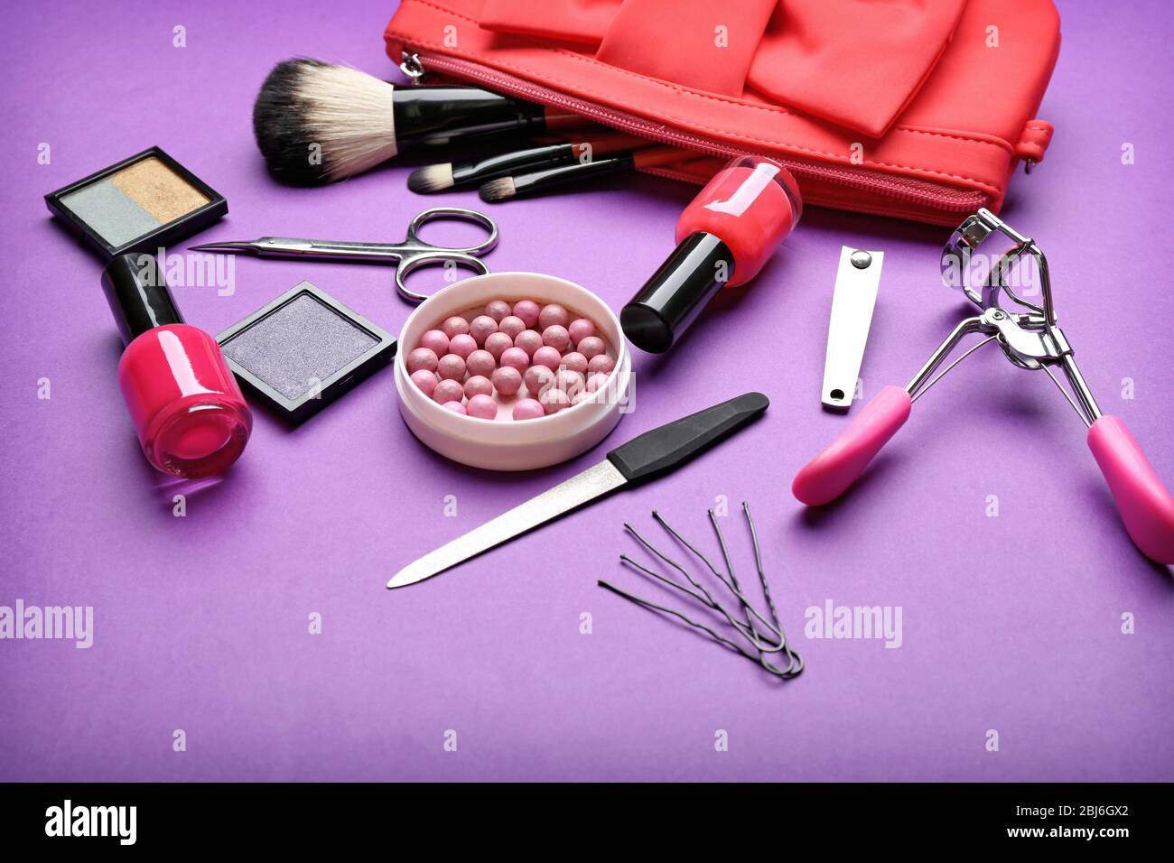 Decorative makeup cosmetics and manicure tools on purple background ...