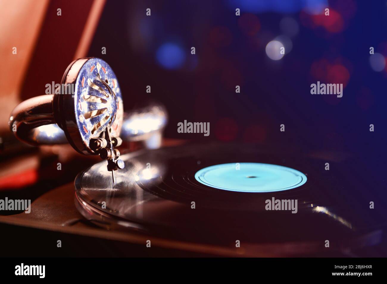 Turntable with vinyl record on dark blurred background Stock Photo - Alamy