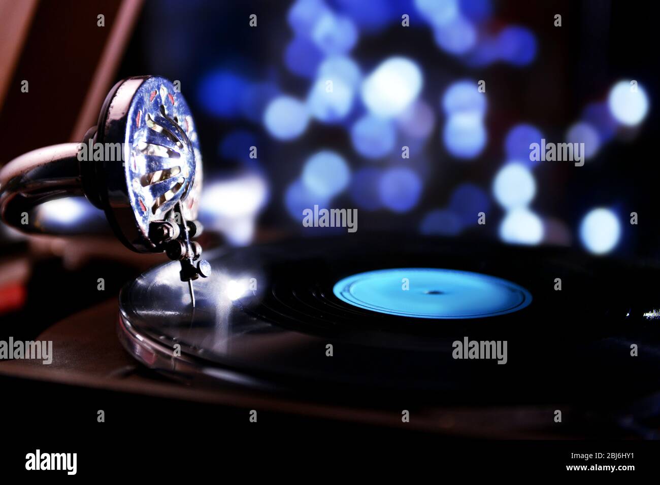 Turntable with vinyl record on dark blurred background Stock Photo - Alamy
