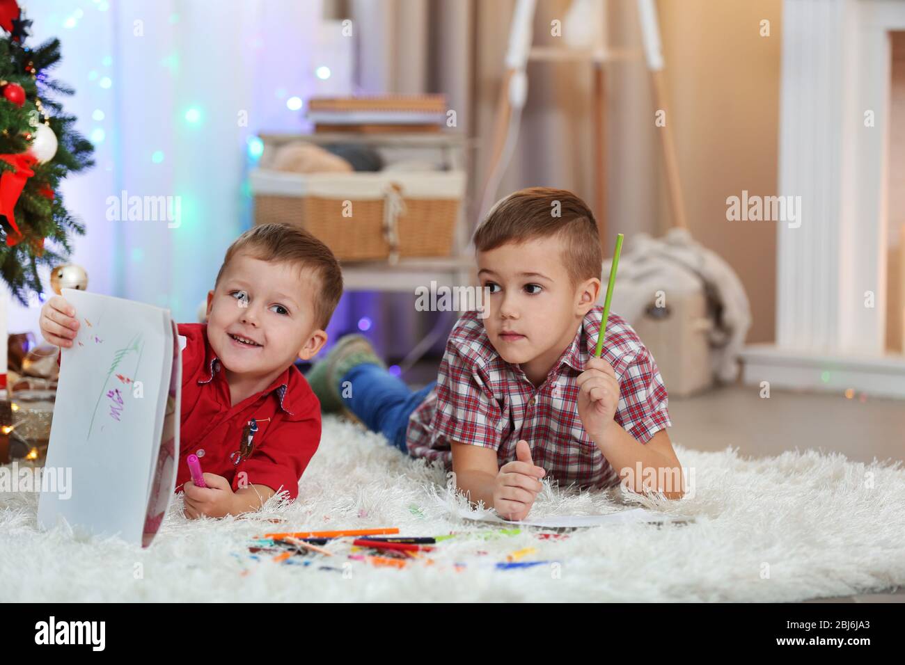 Two cute small brothers drawing on Christmas tree background Stock ...