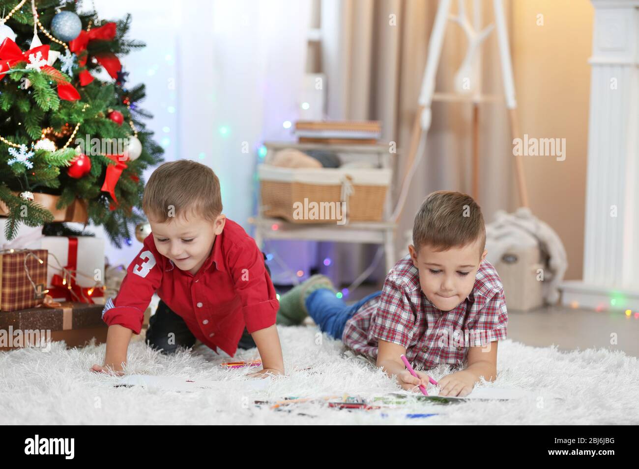 Two cute small brothers drawing on Christmas tree background Stock ...