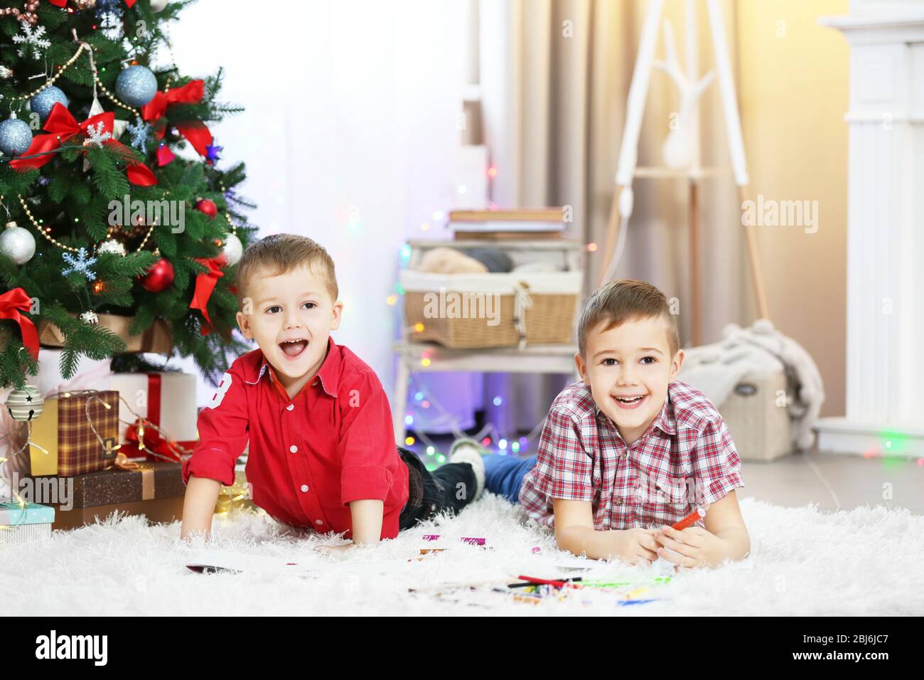 Two cute small brothers drawing on Christmas tree background Stock ...