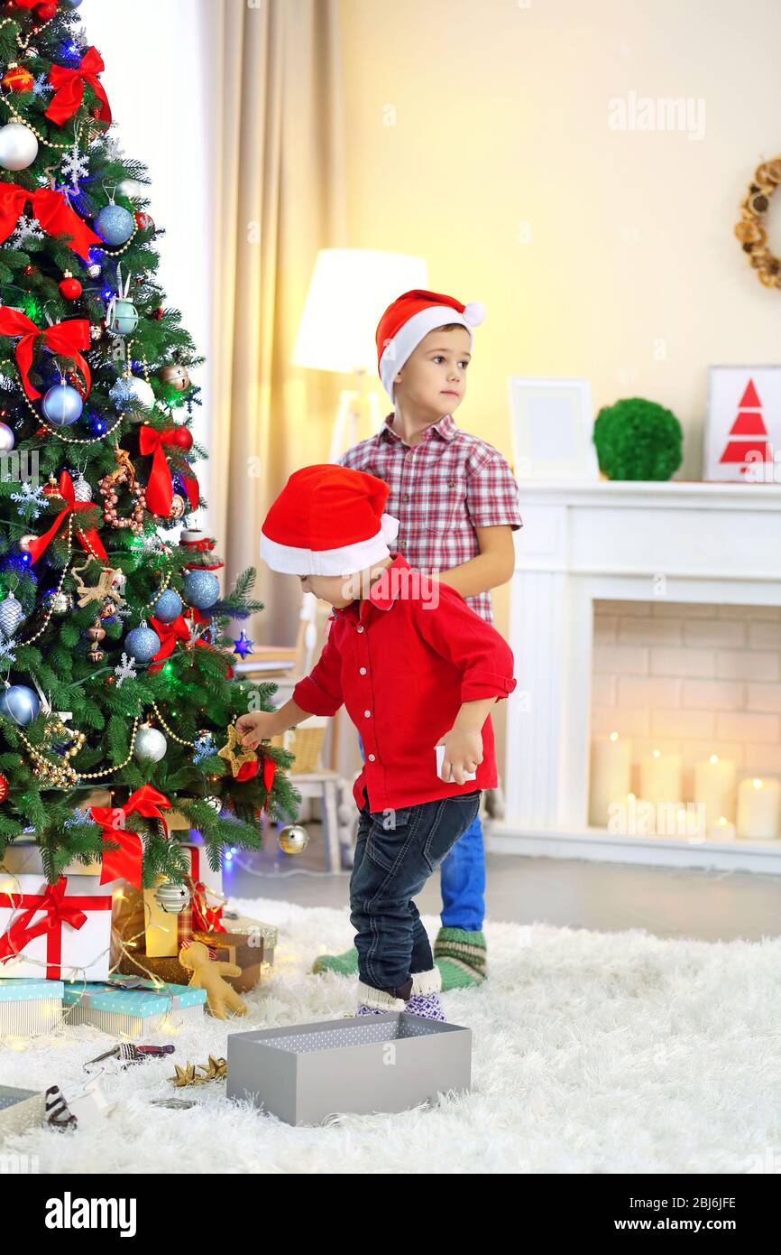 Two cute small brothers decorating Christmas tree Stock Photo - Alamy
