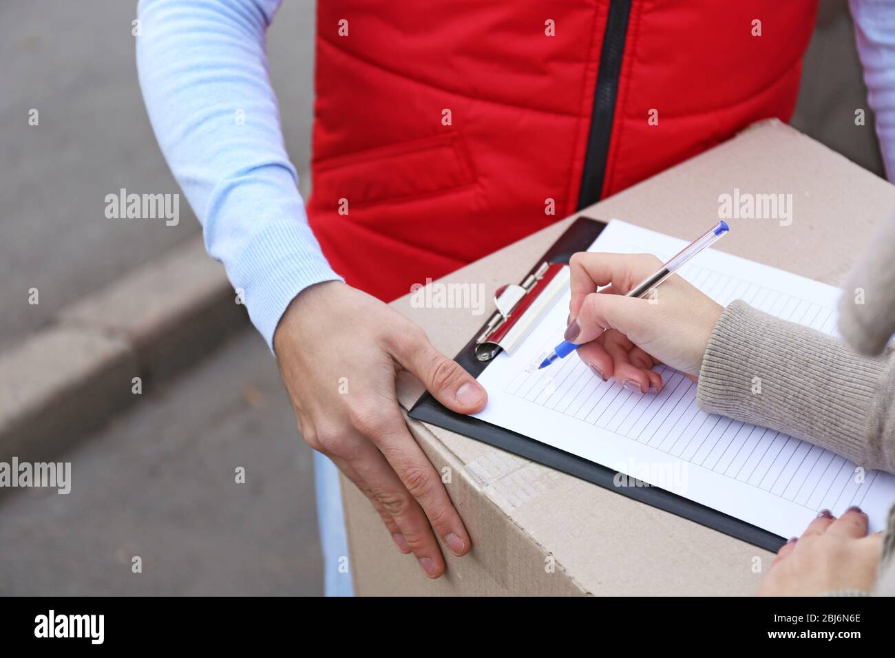Female hand signing delivery form on the box, close-up Stock Photo - Alamy