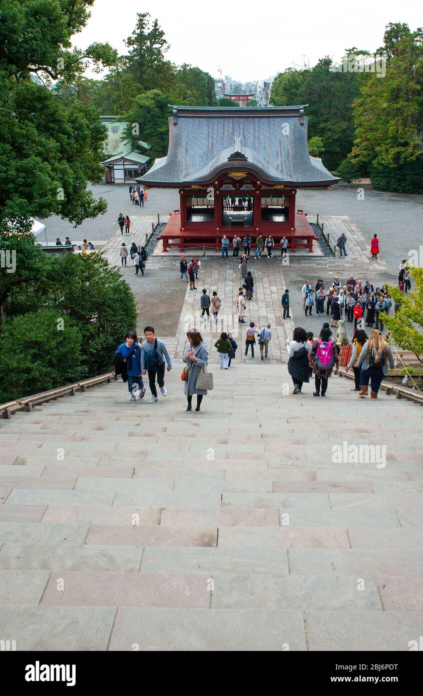 Visitors walking down the staircase at the Tsurugaoka Hachimangū temple ...