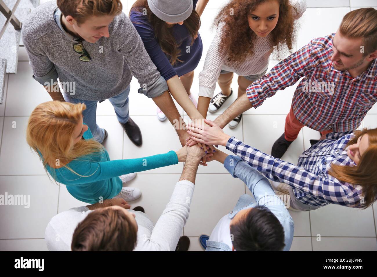 Top view of young people putting hands together Stock Photo - Alamy