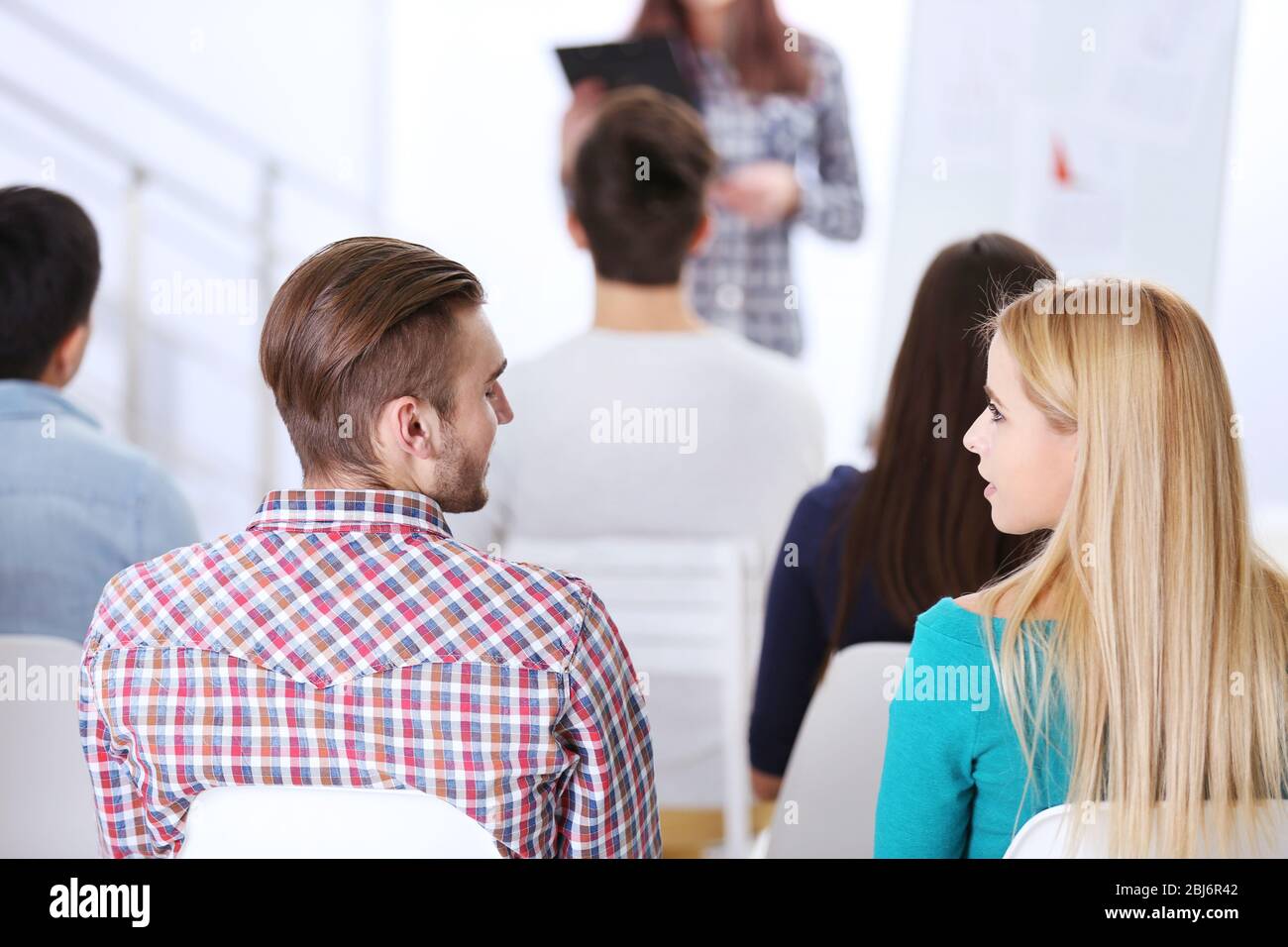 Young people sitting back and talking at the office meeting Stock Photo ...