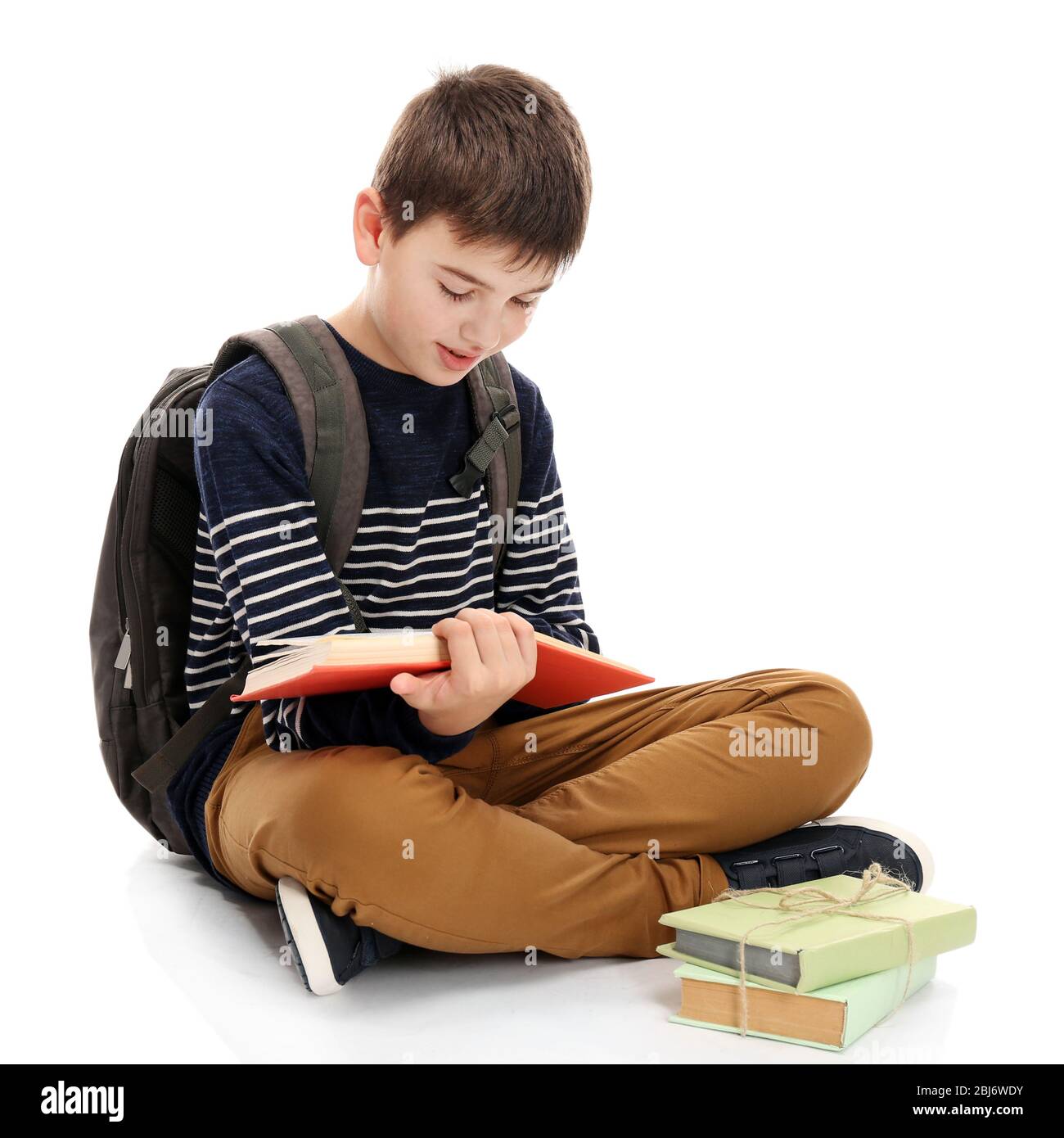 Cute little boy with grey backpack reading books, isolated on white ...