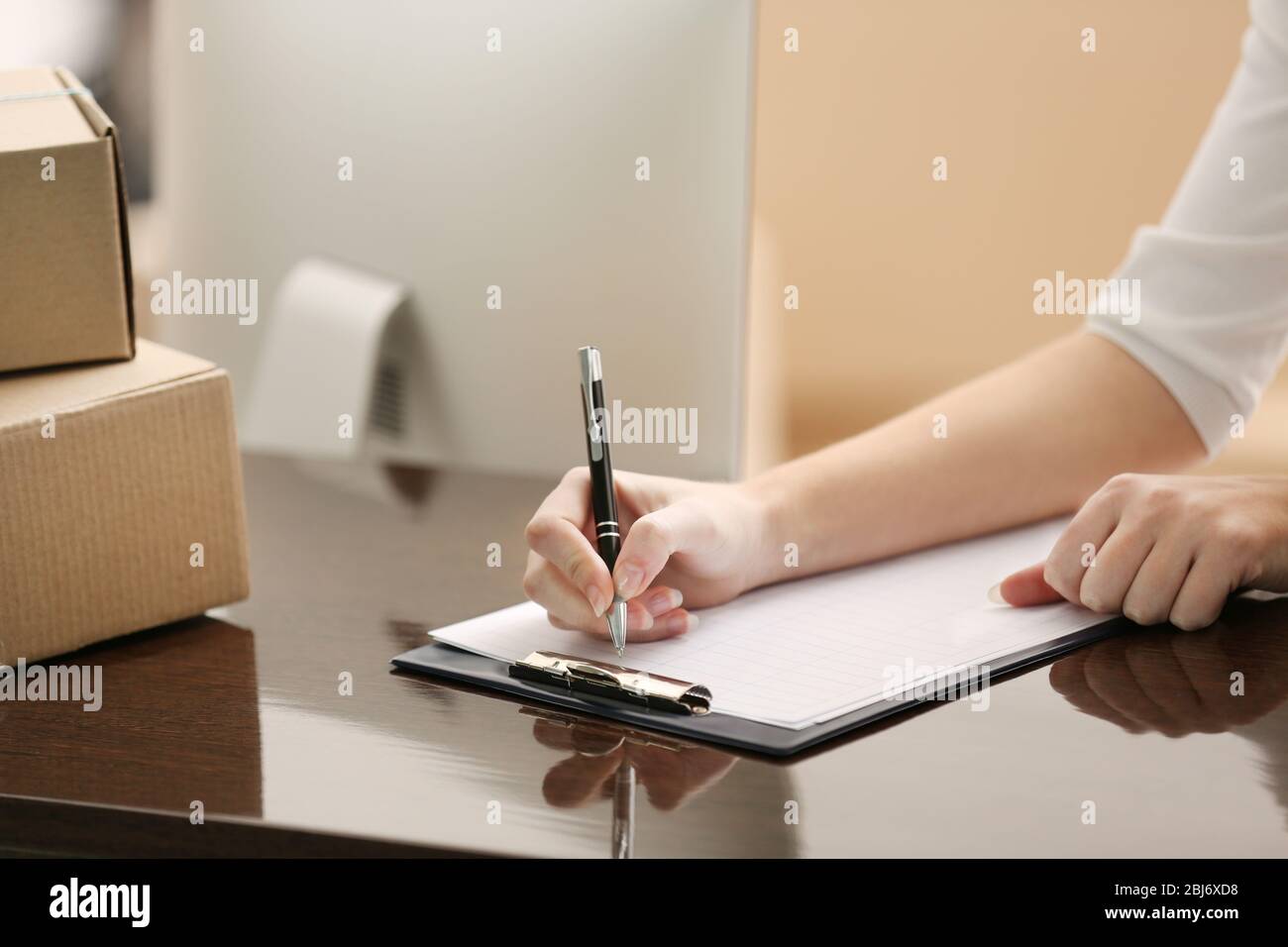 Delivery concept. Woman signs papers among parcels, close up Stock ...