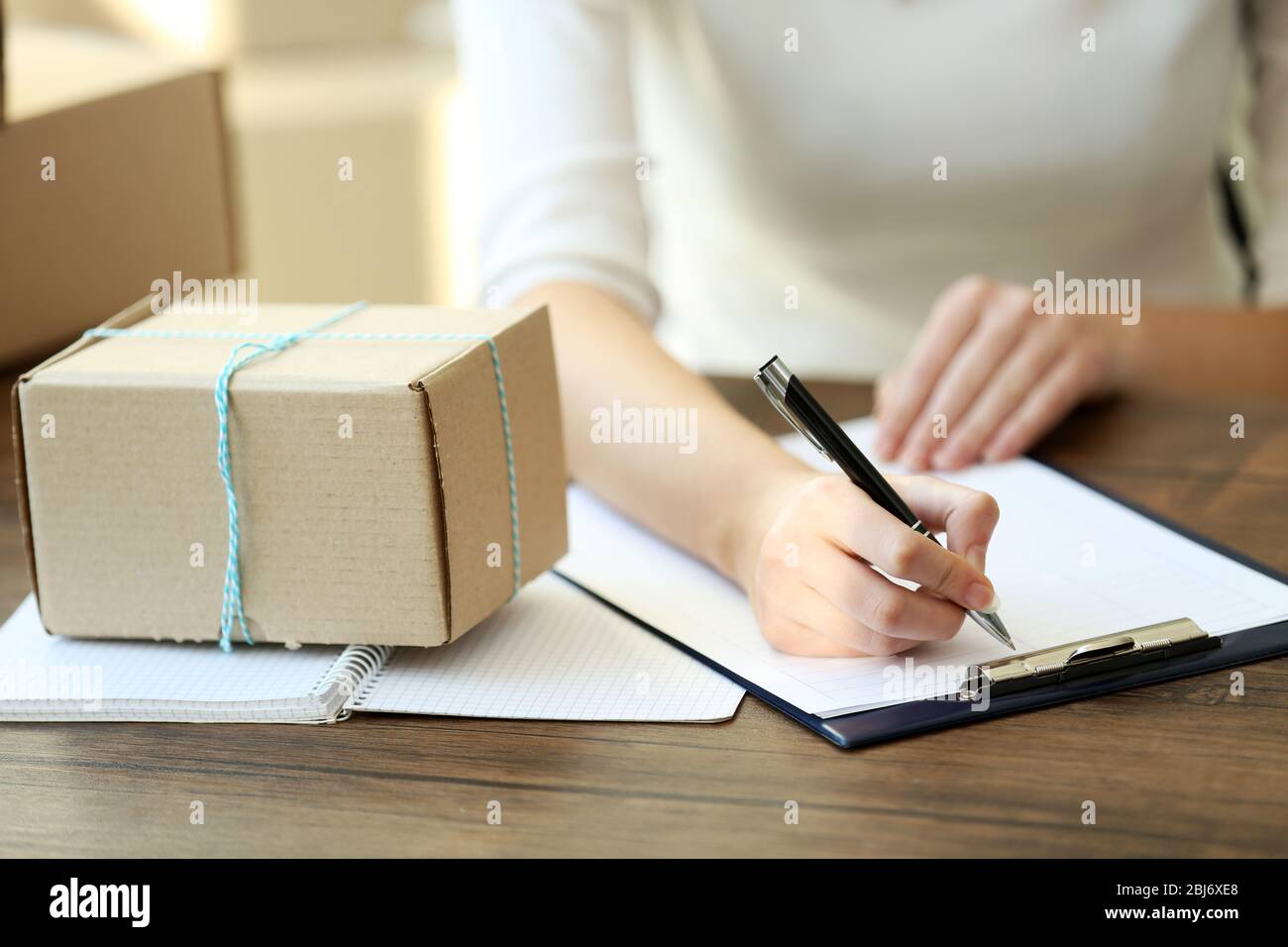 Delivery concept. Woman signs papers among parcels, close up Stock ...
